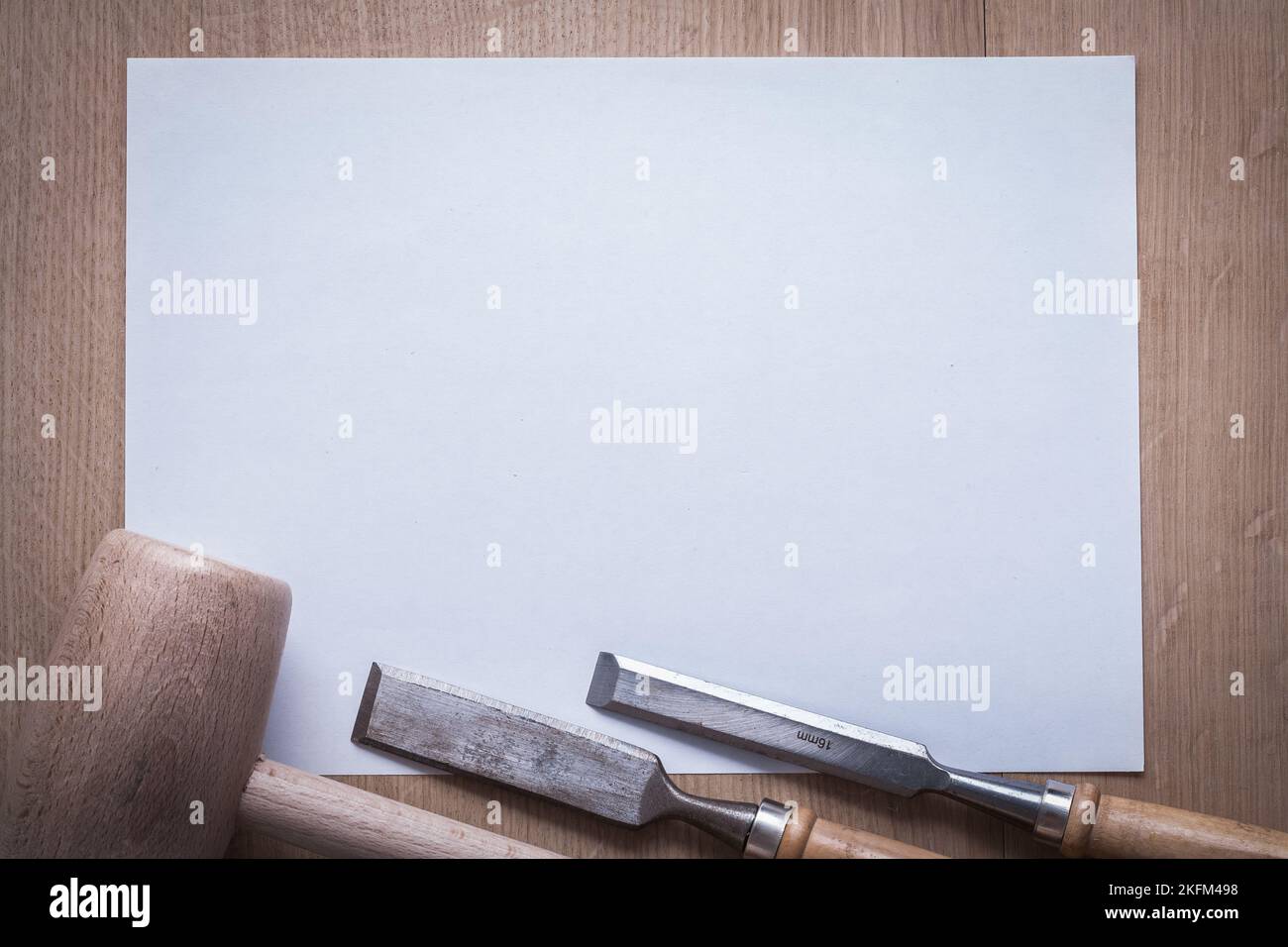 Flat chisels wooden mallet and clean sheet of paper on wood board ...