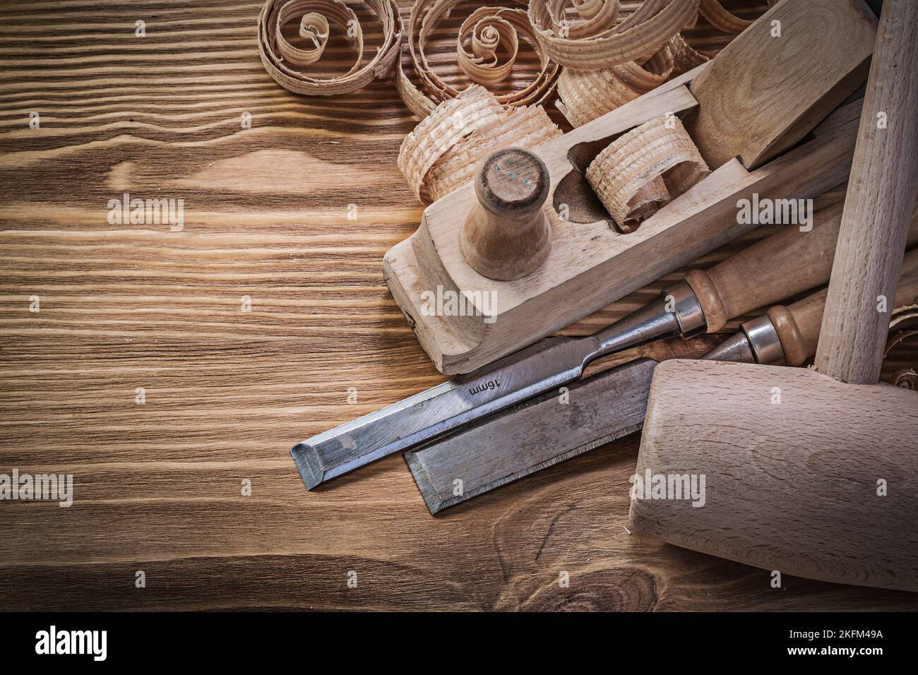 Flat chisels planer curled shavings lump hammer on wood board ...