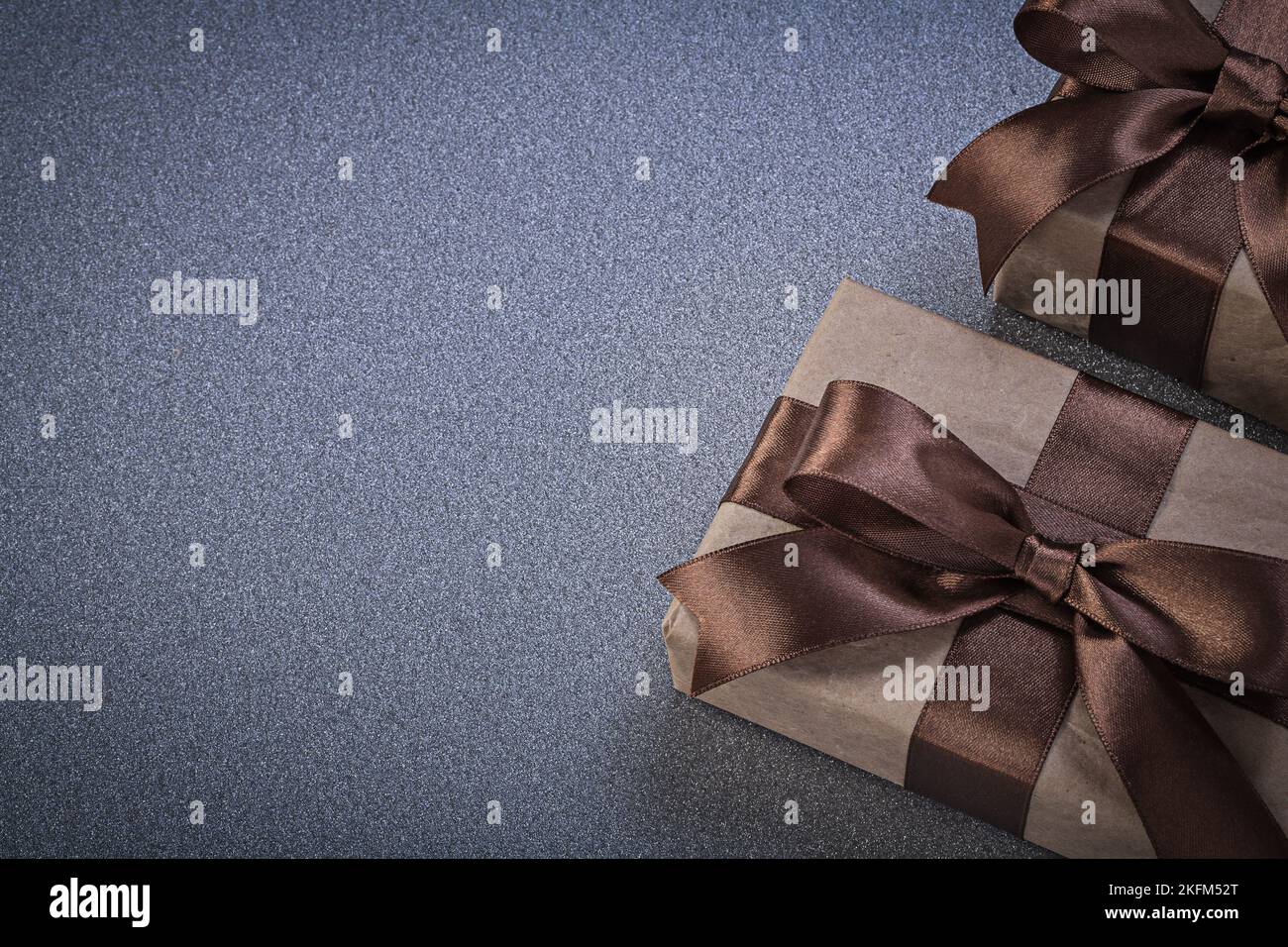 Giftboxes in brown wrapping paper on grey background celebrations ...