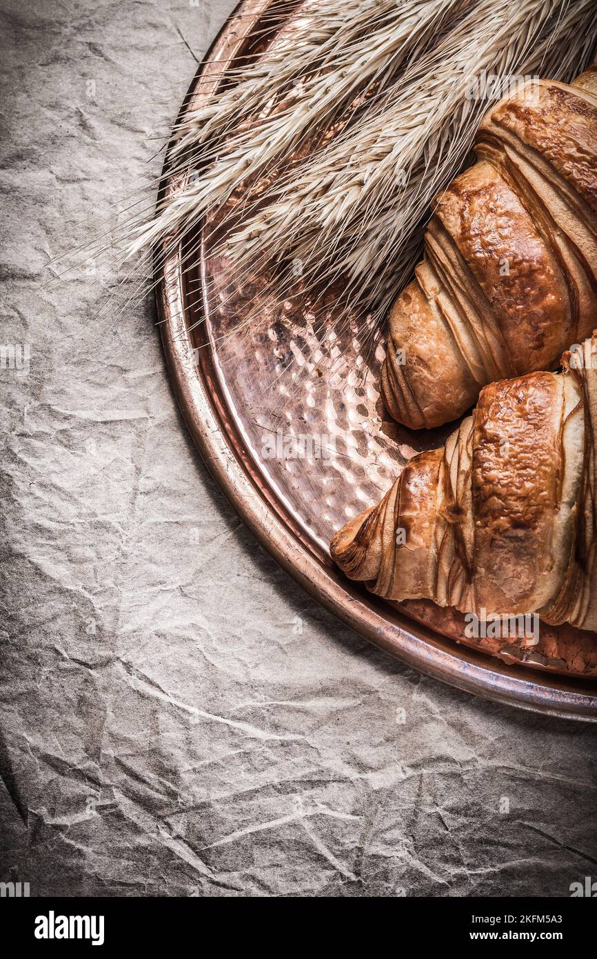 Golden wheat rye ears fresh croissants copper tray on wrapping paper ...