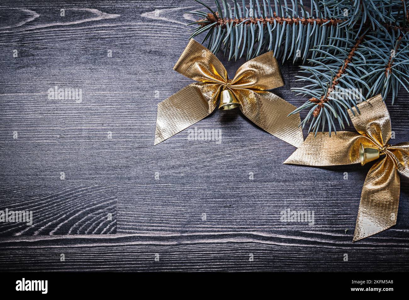 Goldish bows fir tree branch on wooden board holiday concept Stock ...
