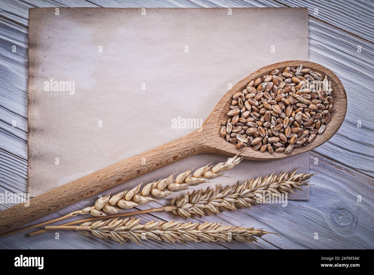 Golden wheat rye ears grain wooden spoon clean vintage paper sheet on ...