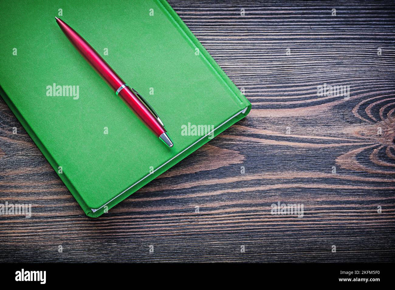 Green notepad ballpoint pen on vintage wood board education concept ...