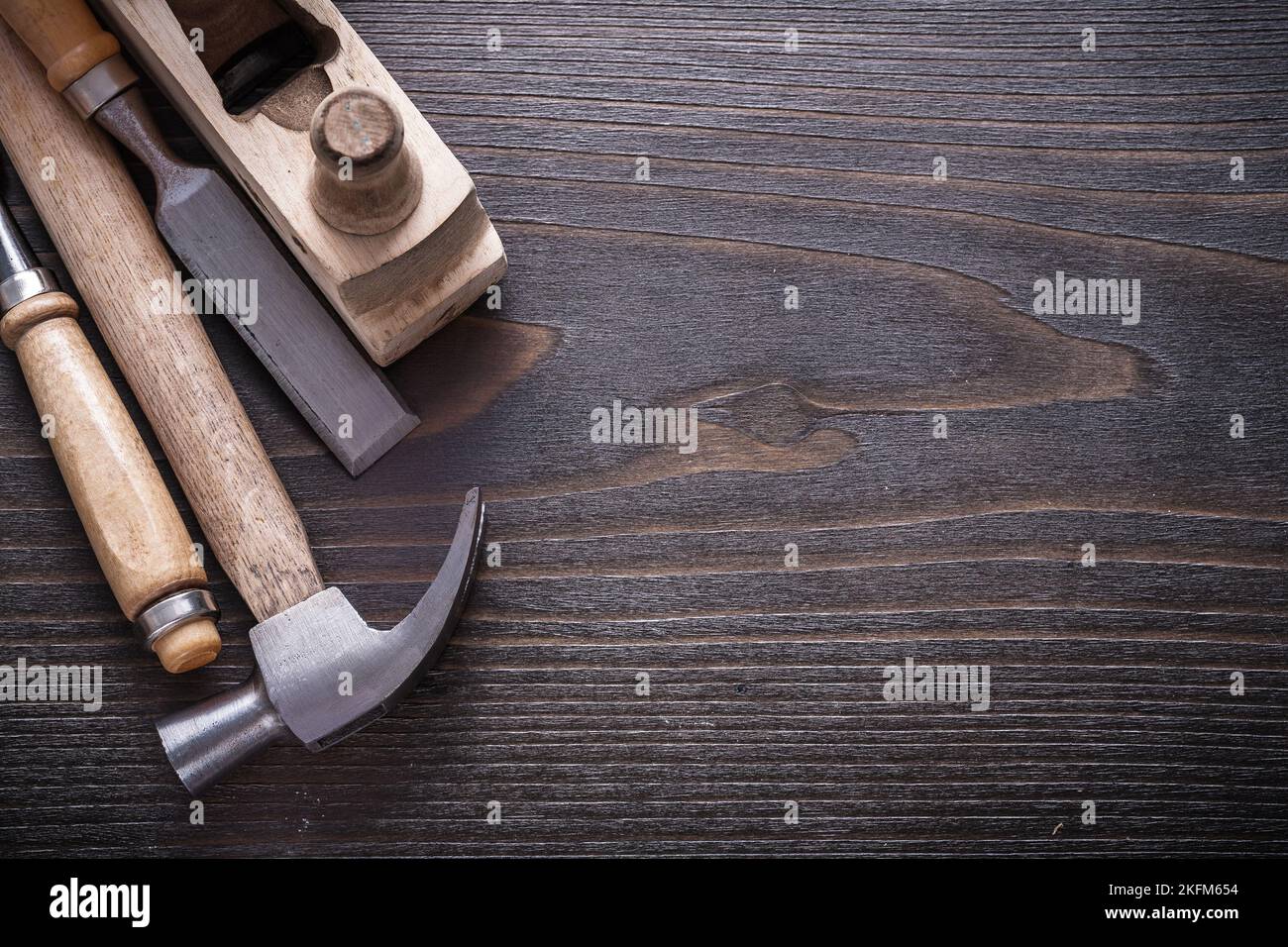 Horizontal view of claw hammer wooden shaving plane and flat chisels on ...