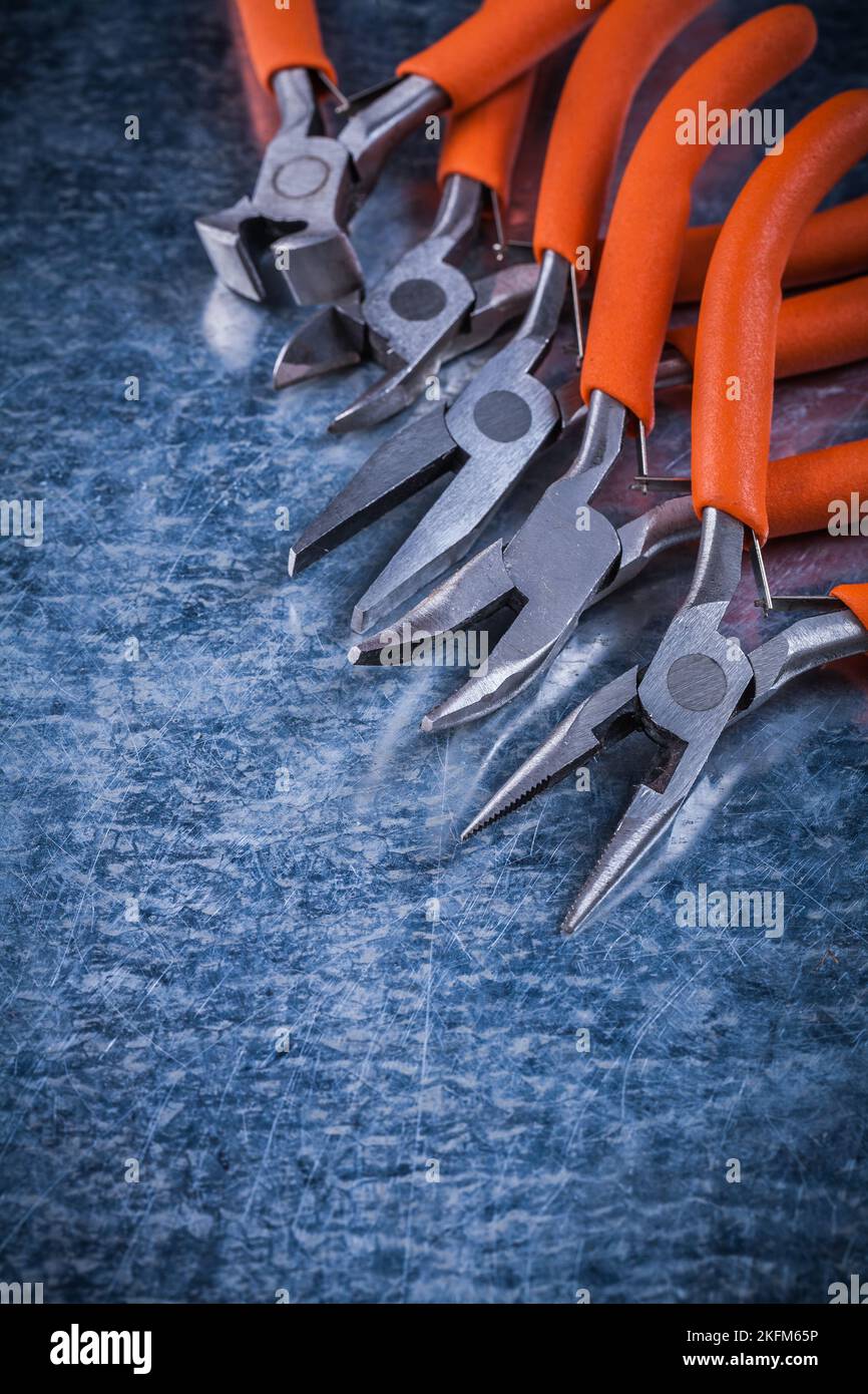 Insulated electric metal nippers pliers on scratched metallic surface ...