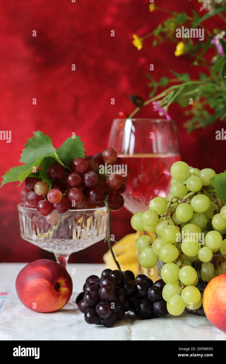 Still life with glass of rose wine, fresh seasonal berries and fruit ...