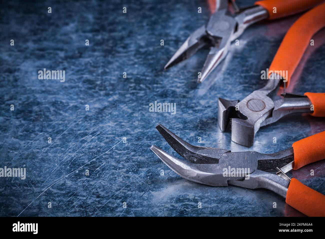 Insulated electric nippers gripping tongs on scratched metallic ...