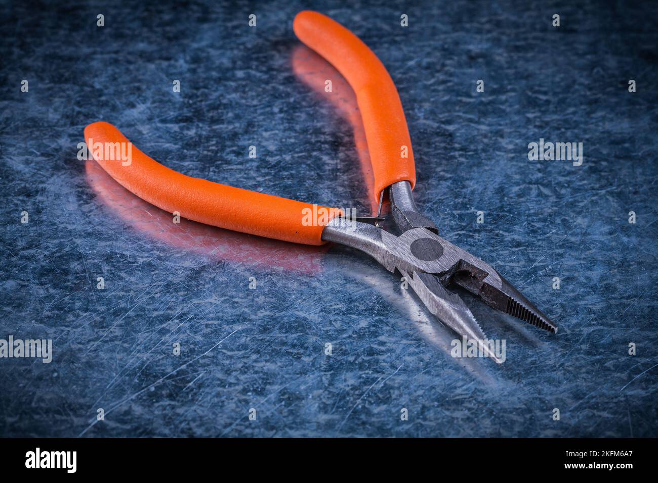 Insulated electric metal gripping tongs on metallic background ...
