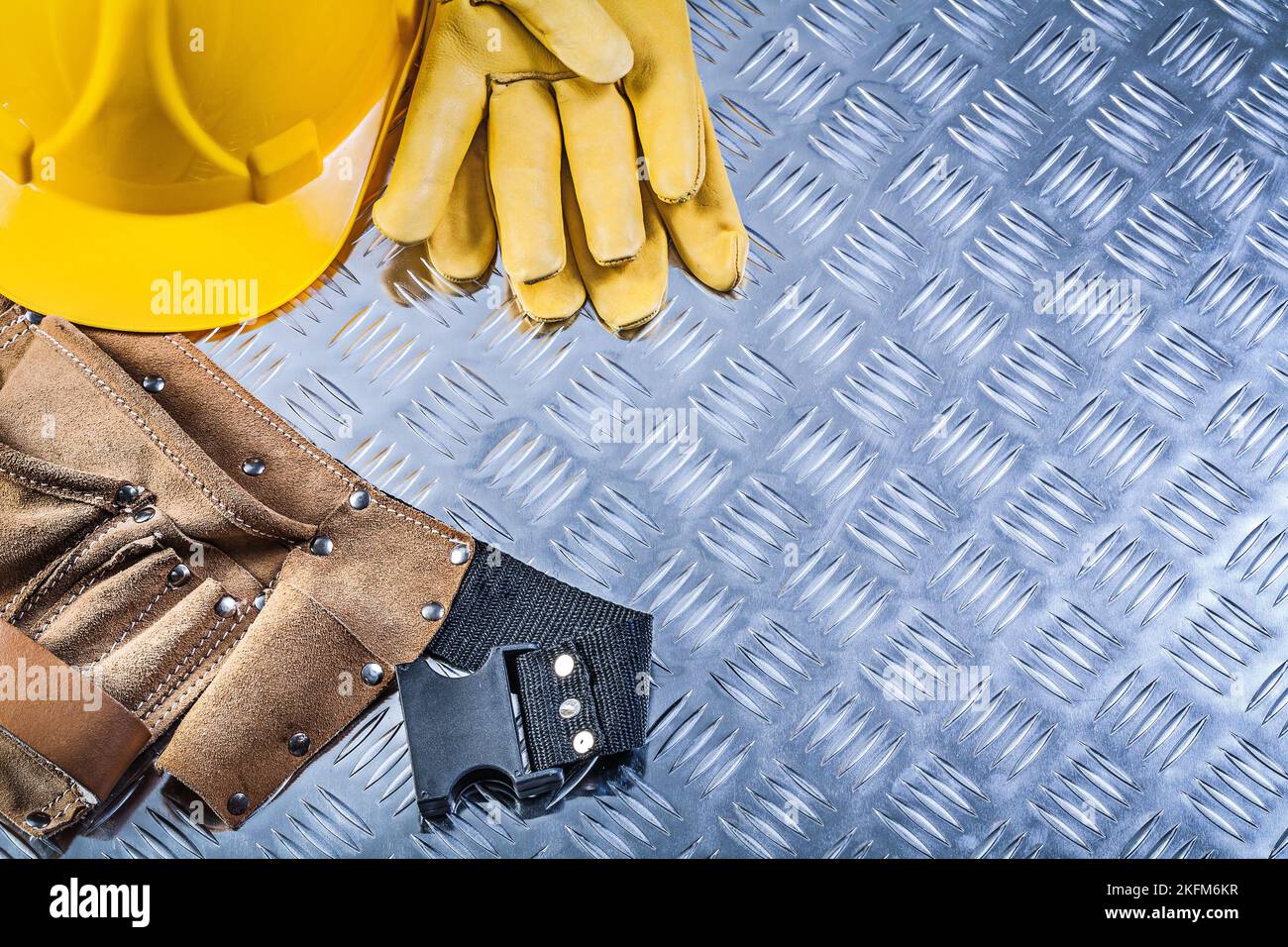 Leather building belt protective gloves hard hat on corrugated metal ...
