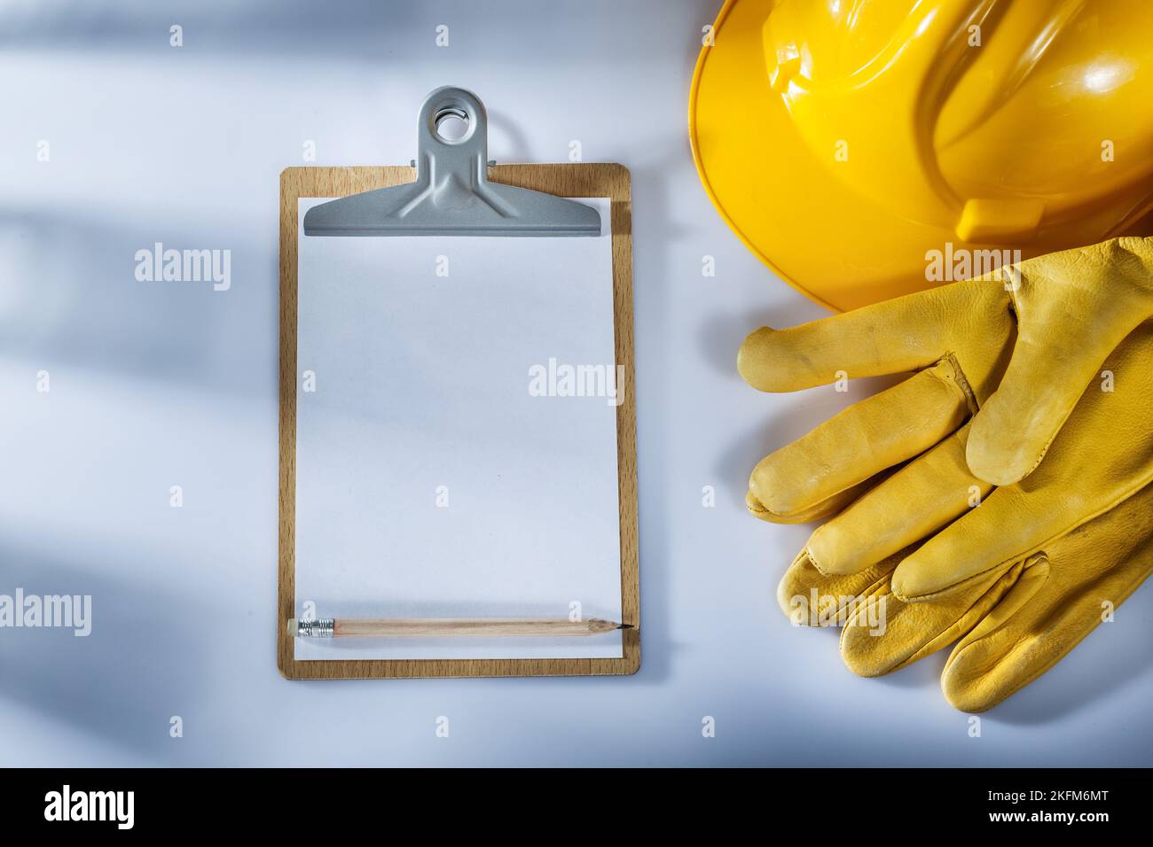 Leather protective gloves building helmet clipboard pencil on white ...