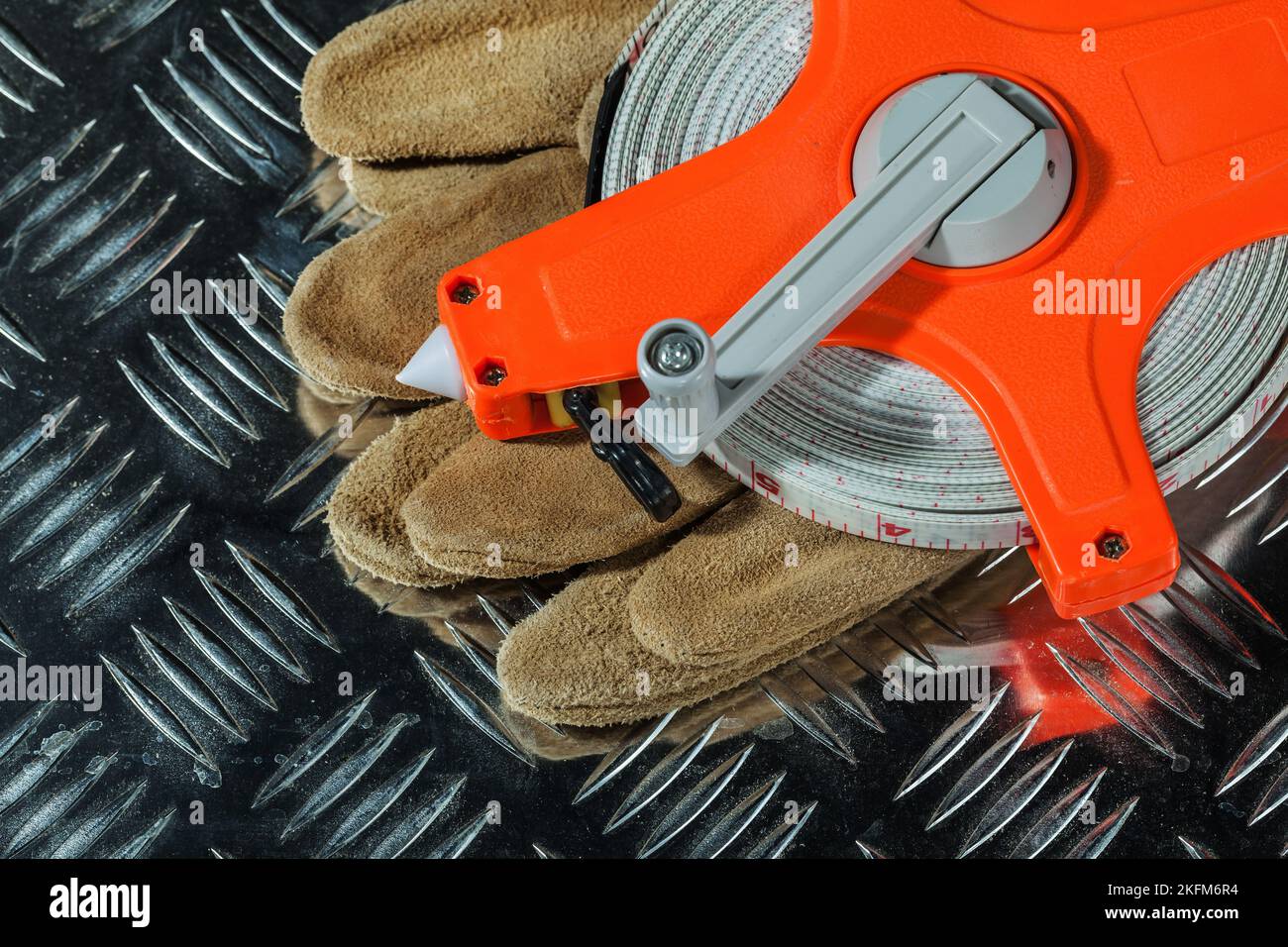Leather protective gloves measuring tape on corrugated metal sheet ...