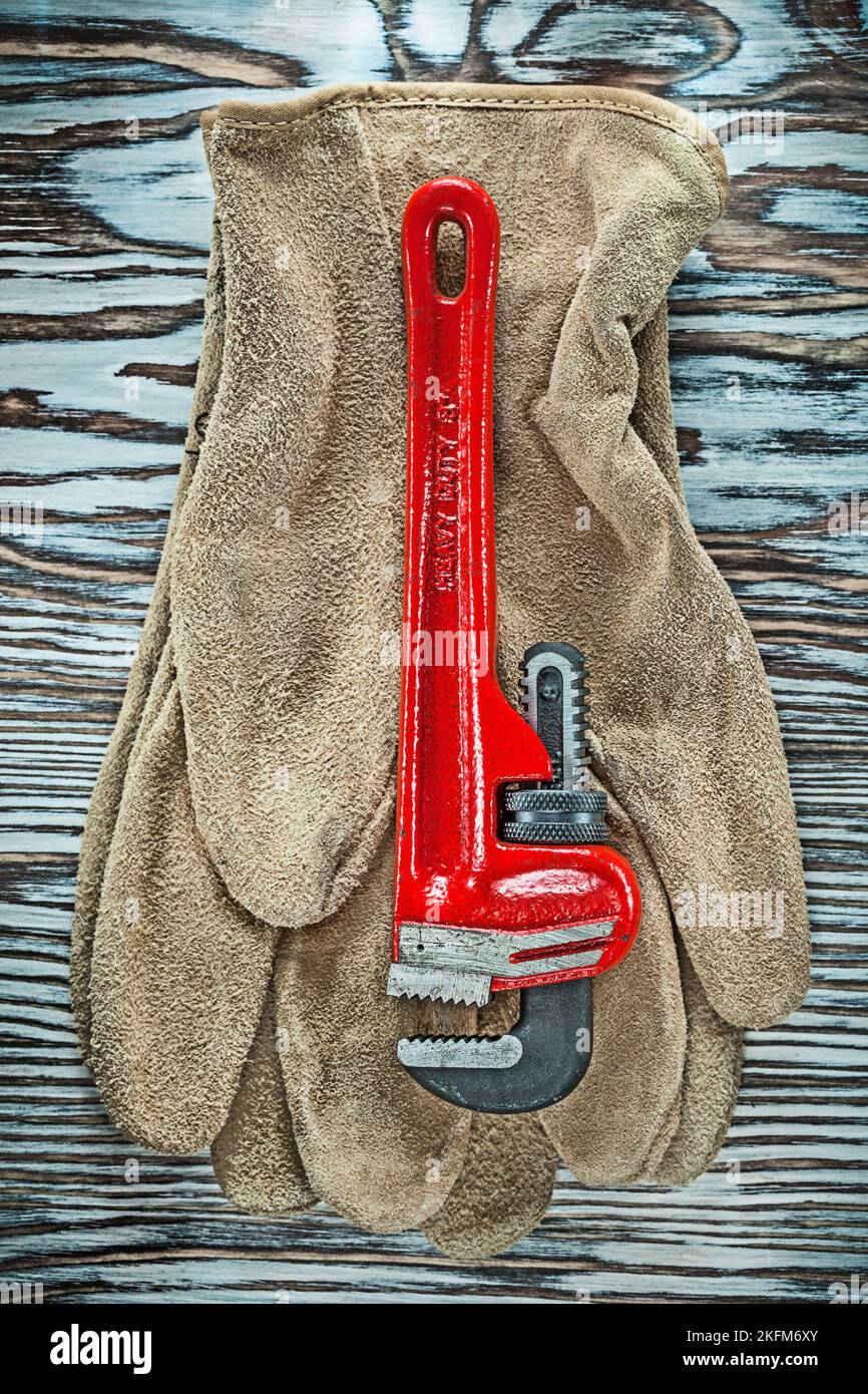 Leather safety gloves monkey wrench on wooden board Stock Photo - Alamy