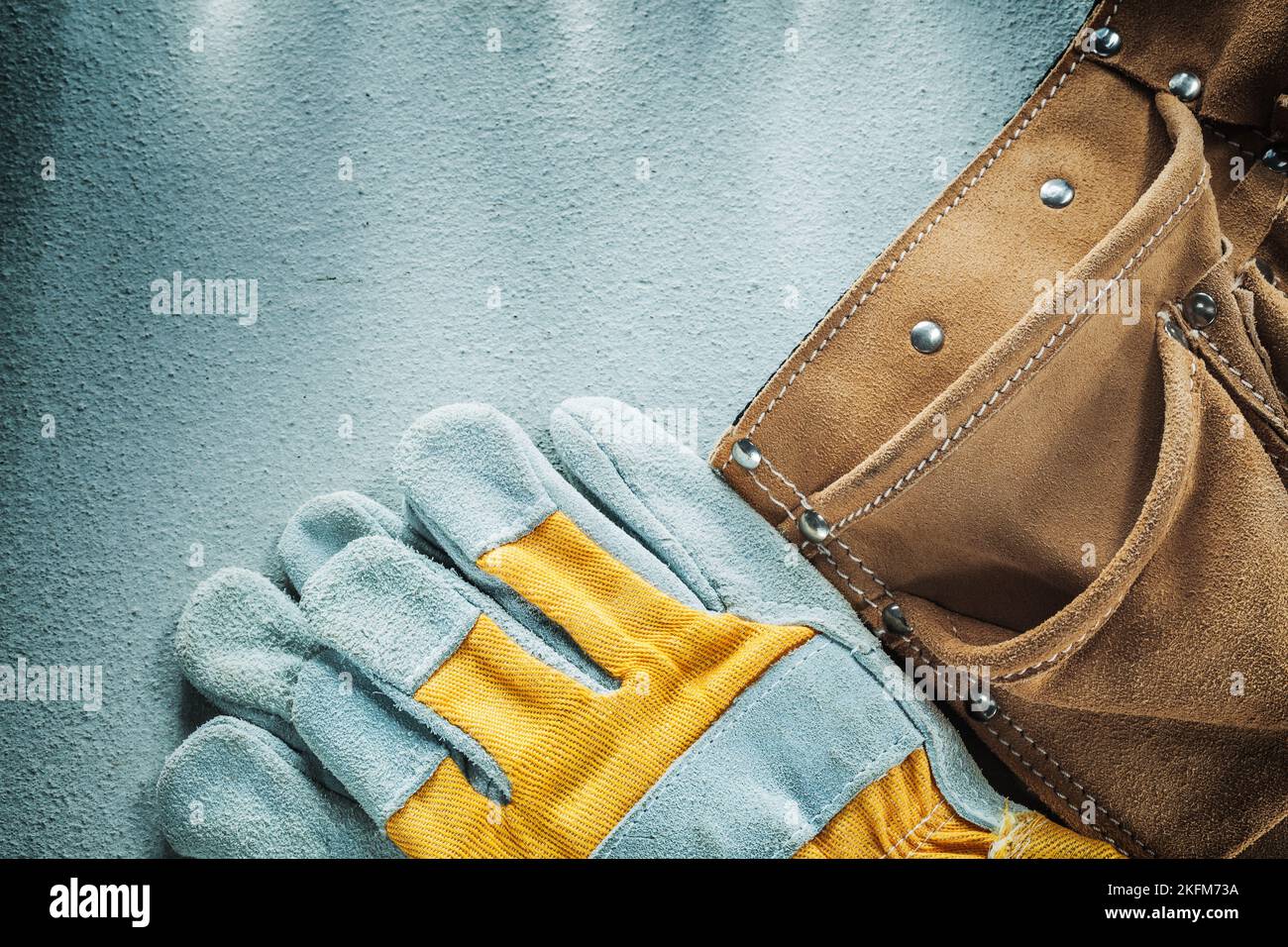 Leather tool belt protective gloves on concrete background Stock Photo ...