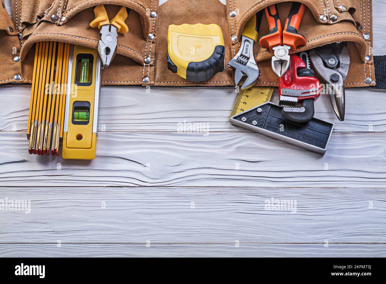 Leather tool belt with tooling on wooden board construction concept ...