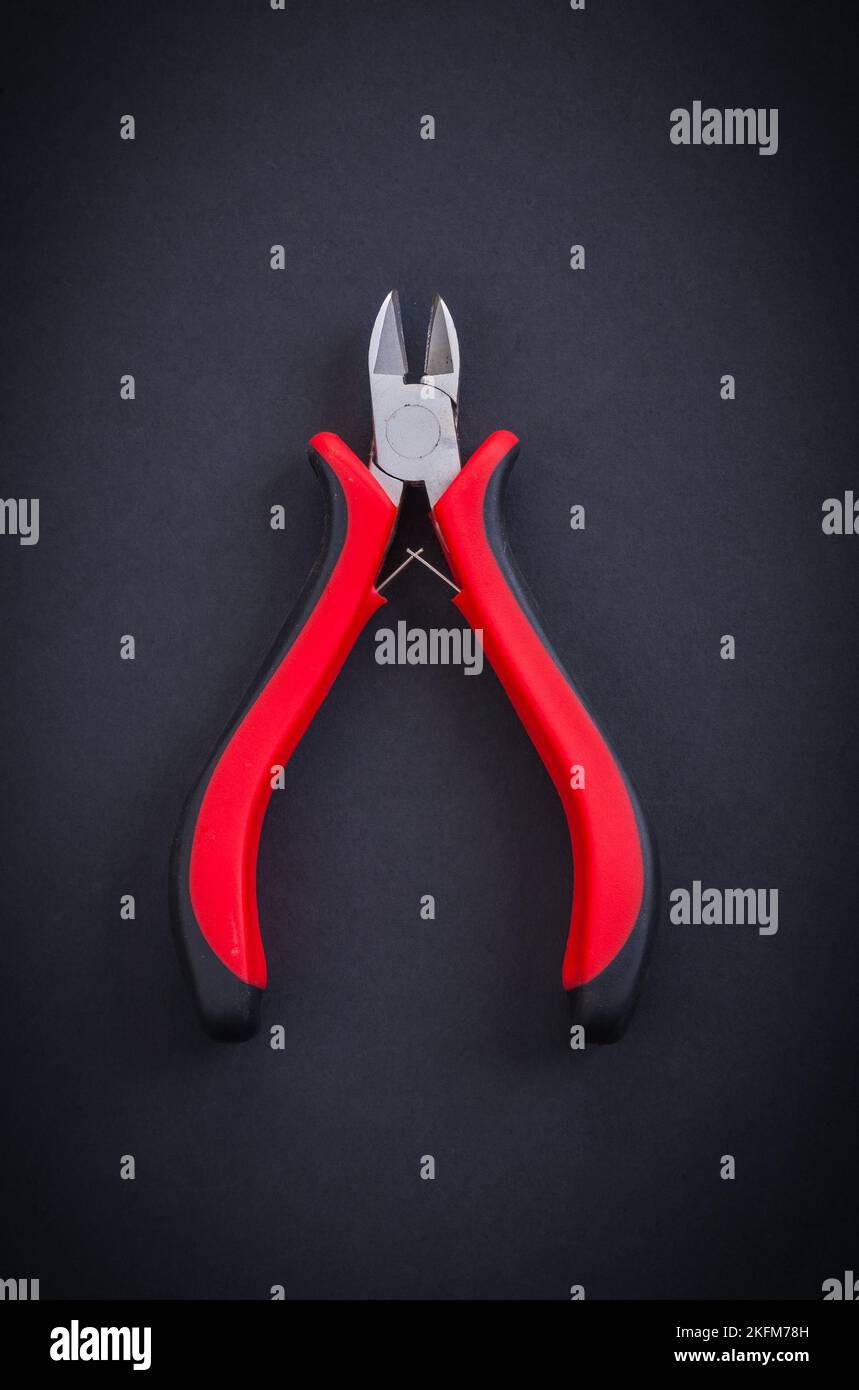 little nippers with red handles on black background Stock Photo - Alamy