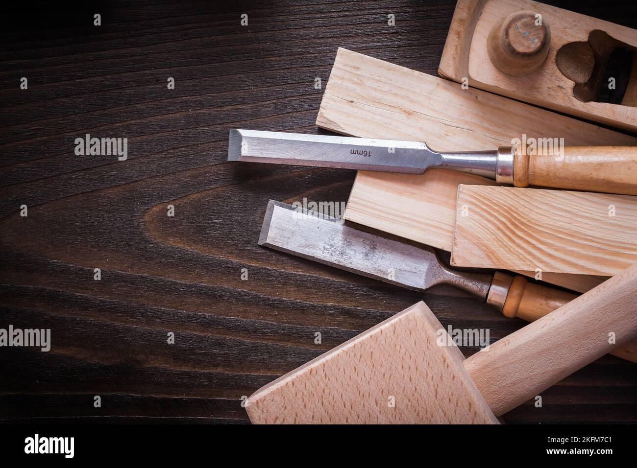 Lump hammer shaving plane flat chisels and wooden bricks on brown board ...