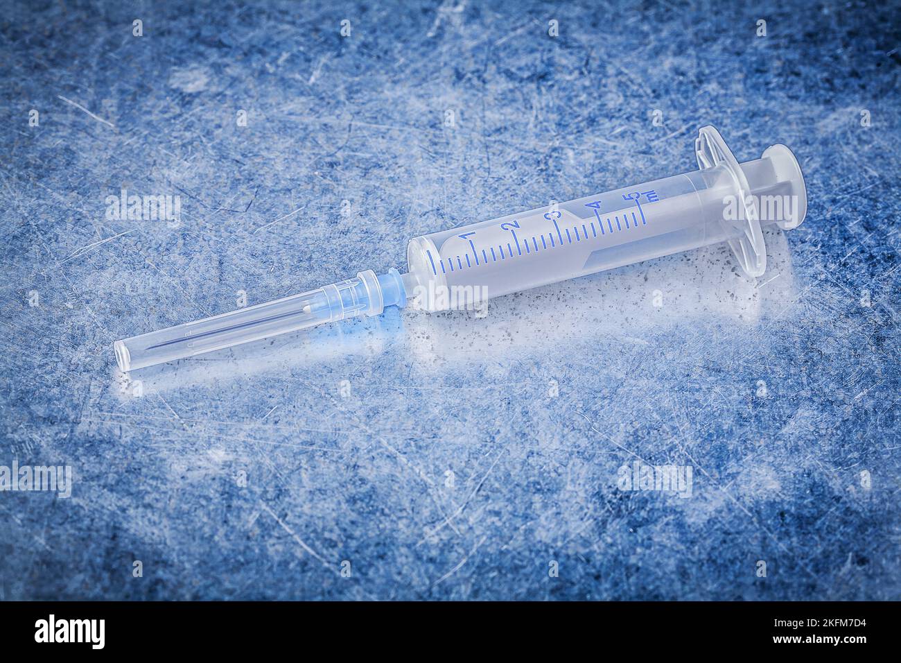 Medical disposable needle injector on scratched metallic background ...