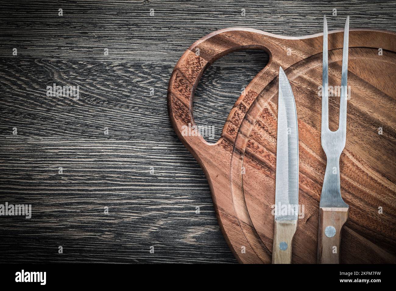 Meat fork knife chopping board on vintage wooden background Stock Photo ...