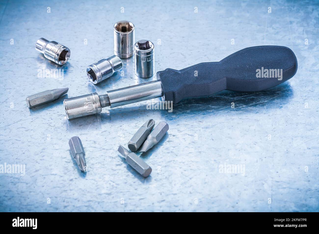 Metallic background with black screwdriver and group of steel screw ...