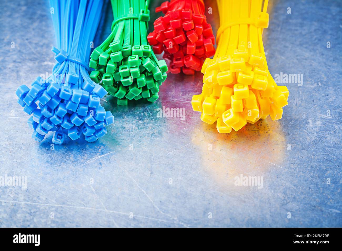 Multicolored plastic tying cables on scratched metallic background ...