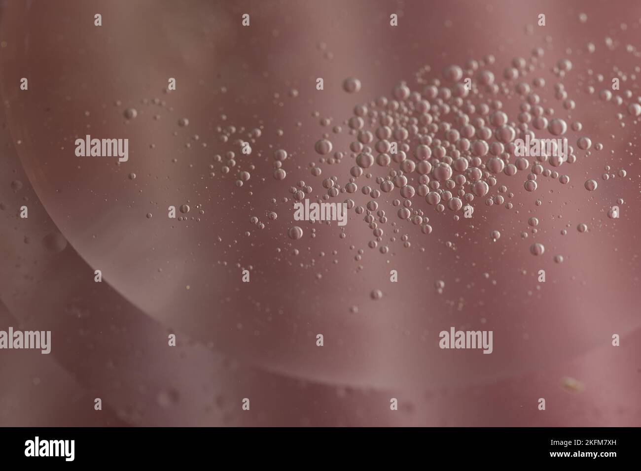 A small drops of oil in water on a purple background Stock Photo - Alamy