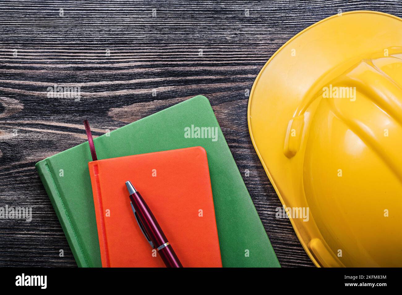 Notepads pen hard hat on vintage wooden board construction concept ...