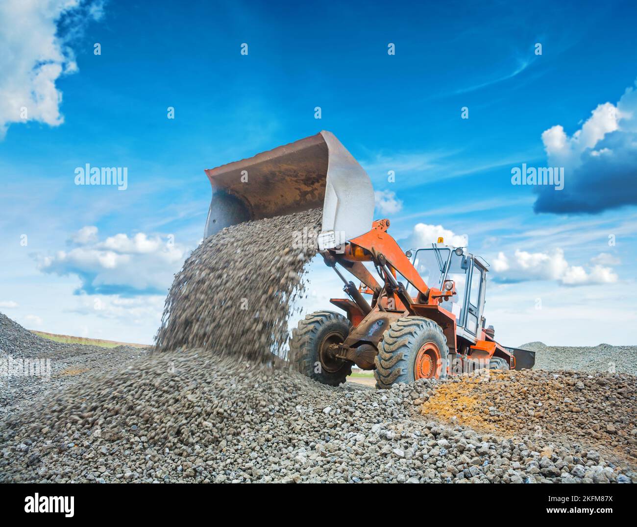 old wheel loader excavator loadding gravel Stock Photo - Alamy