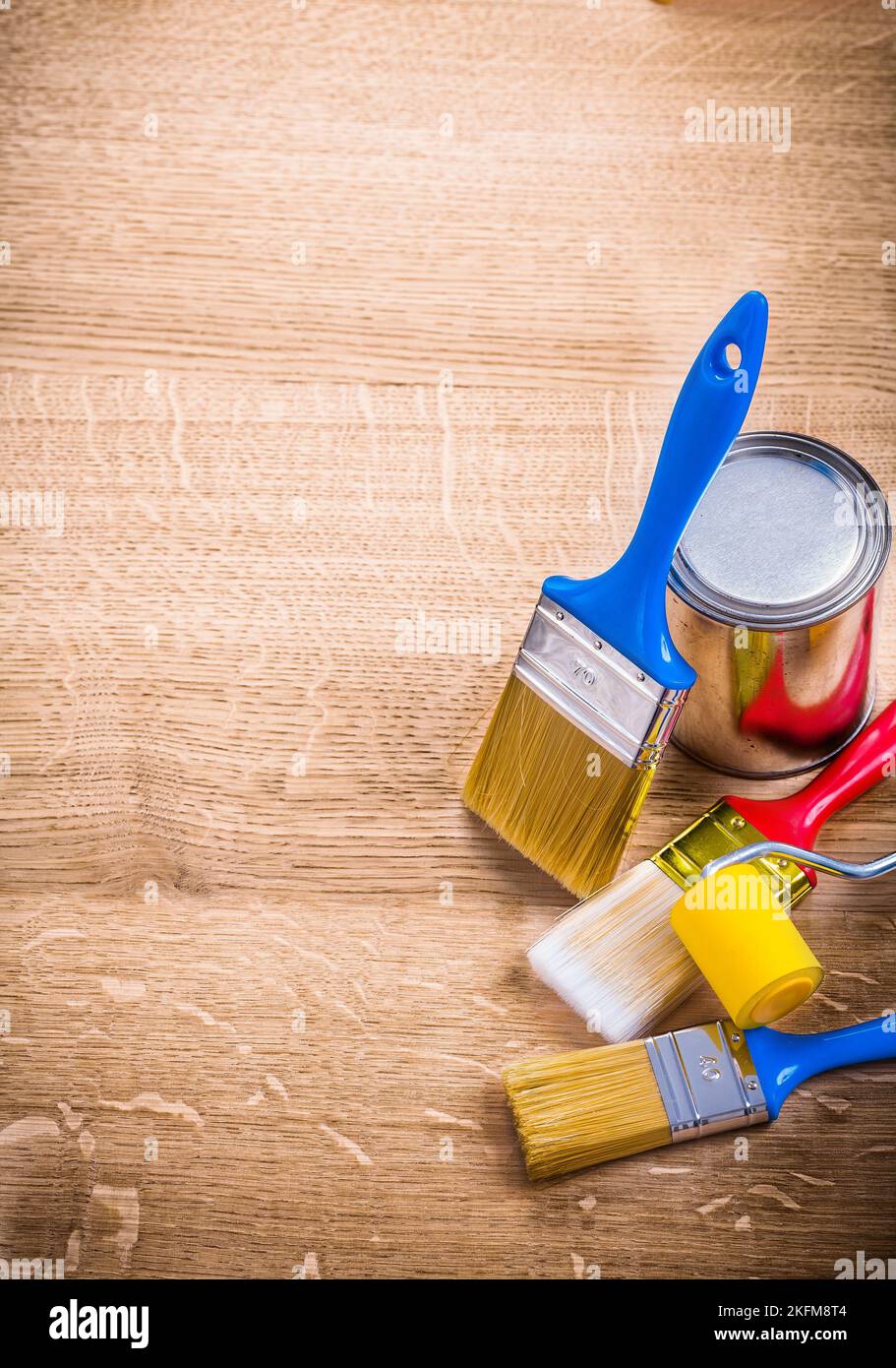 organized copyspace three paint brushes roller can on wooden board ...