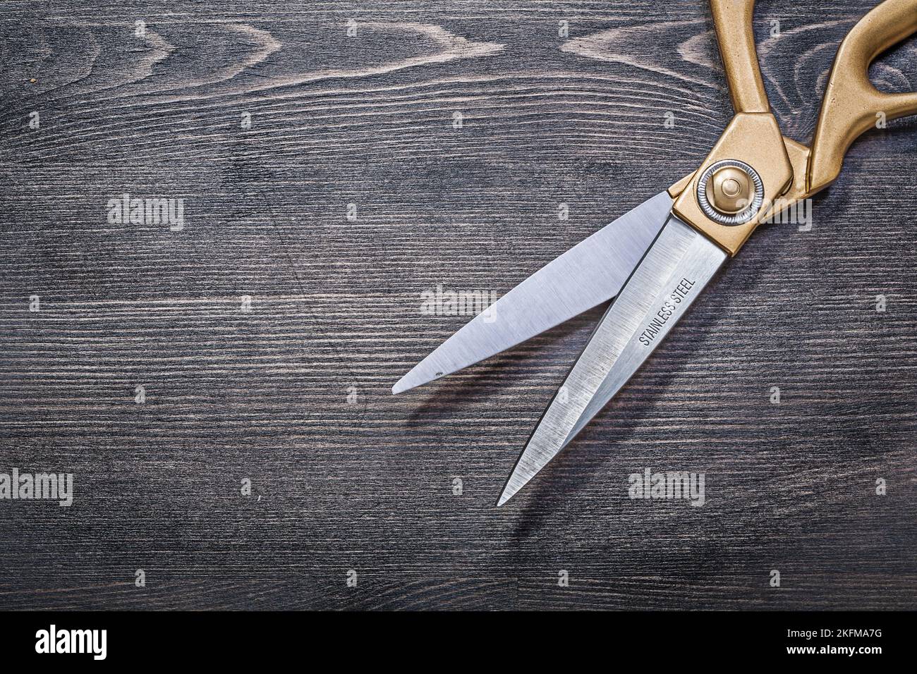 Pair of golden scissors on vintage wooden board Stock Photo - Alamy
