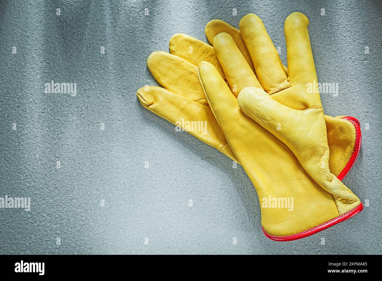 Pair of leather protective gloves on concrete surface construction ...