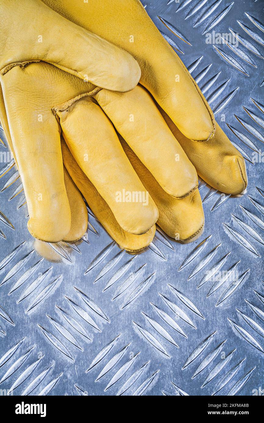 Pair of leather protective gloves on corrugated metal plate top view ...