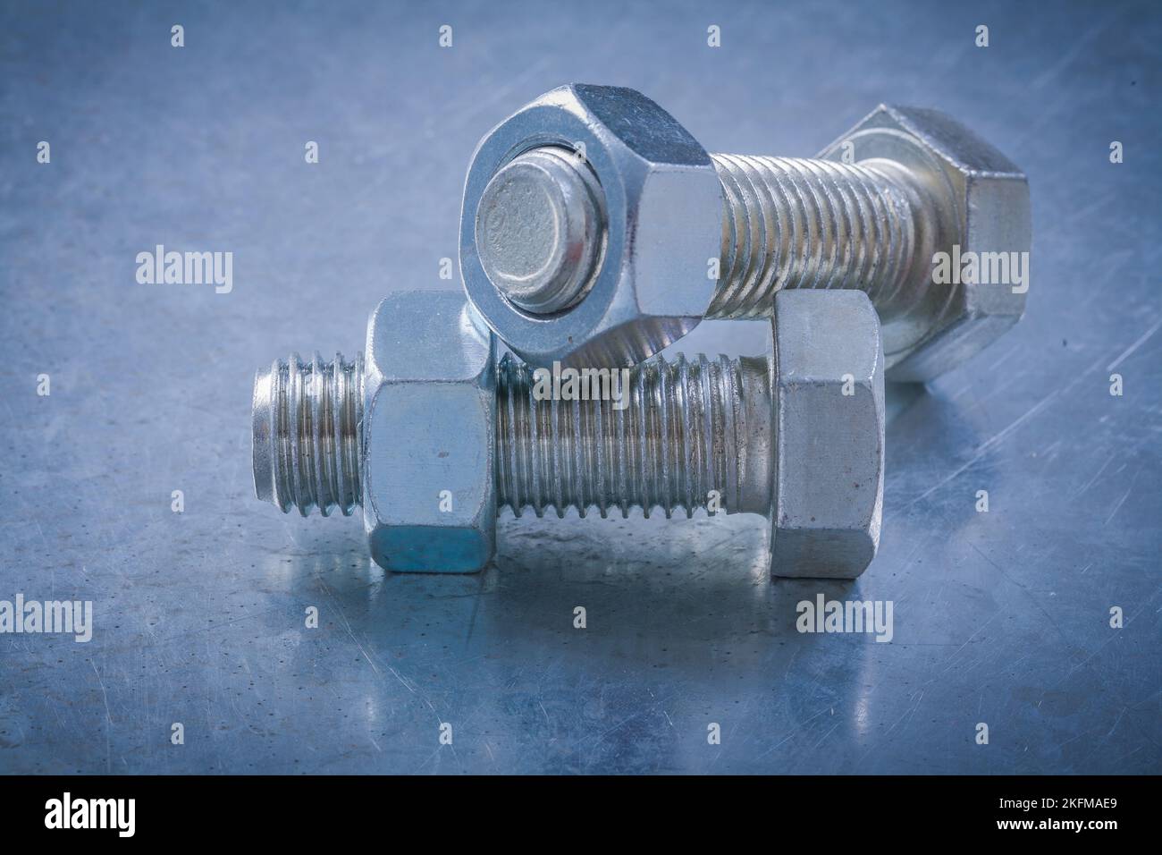 Pair of threaded bolts screw-nuts on metallic surface construction ...