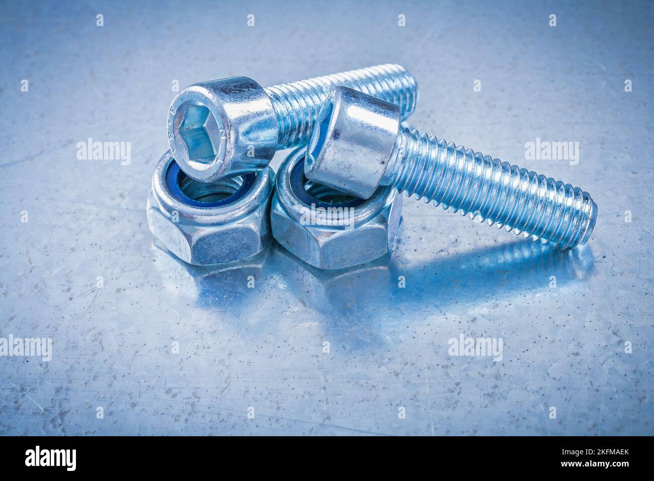 Pair of threaded screw nuts and bolt details on metallic background ...