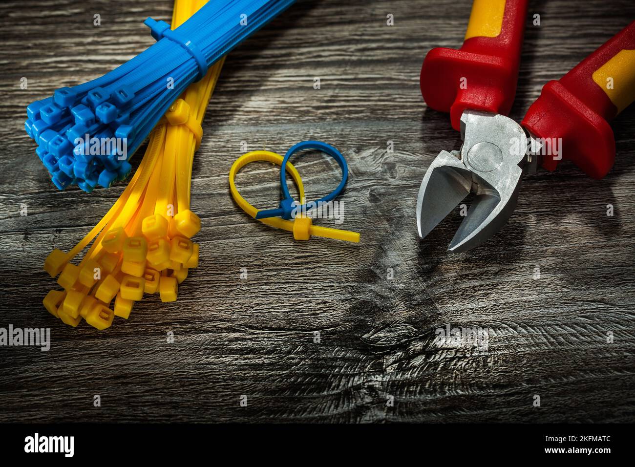 Plastic cables cutting pliers on vintage wooden board Stock Photo - Alamy