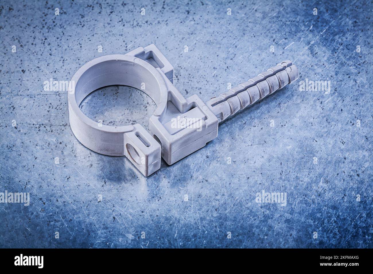 Plastic water pipe clamp on metallic background construction concept ...