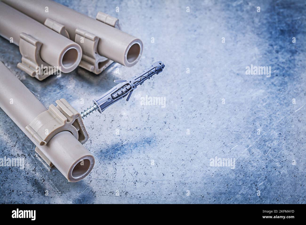 Plastic water pipe clamps on metallic background construction concept ...