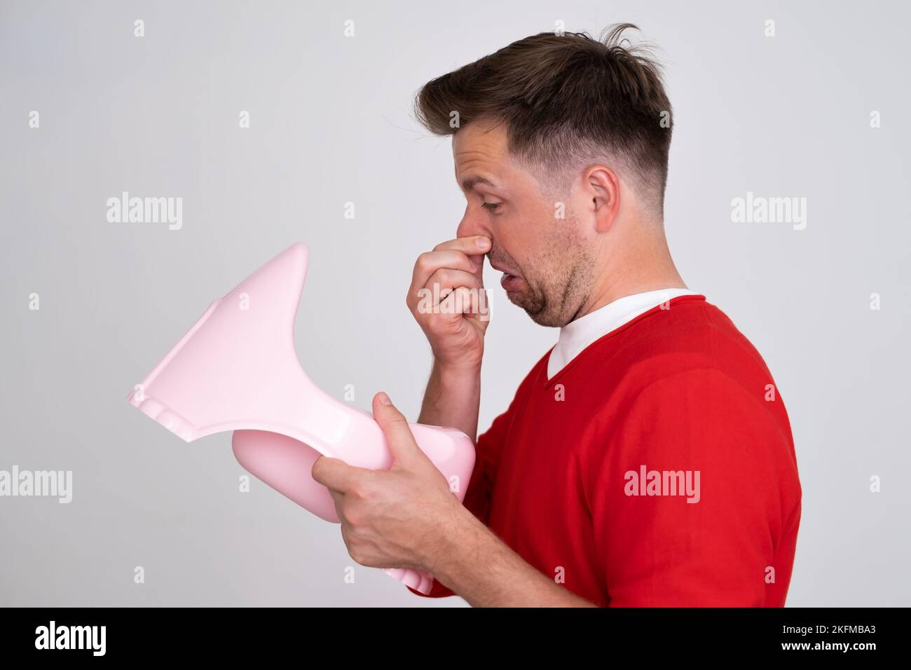 Disgusted caucasian man smell his son potty. Everyday parents chores ...