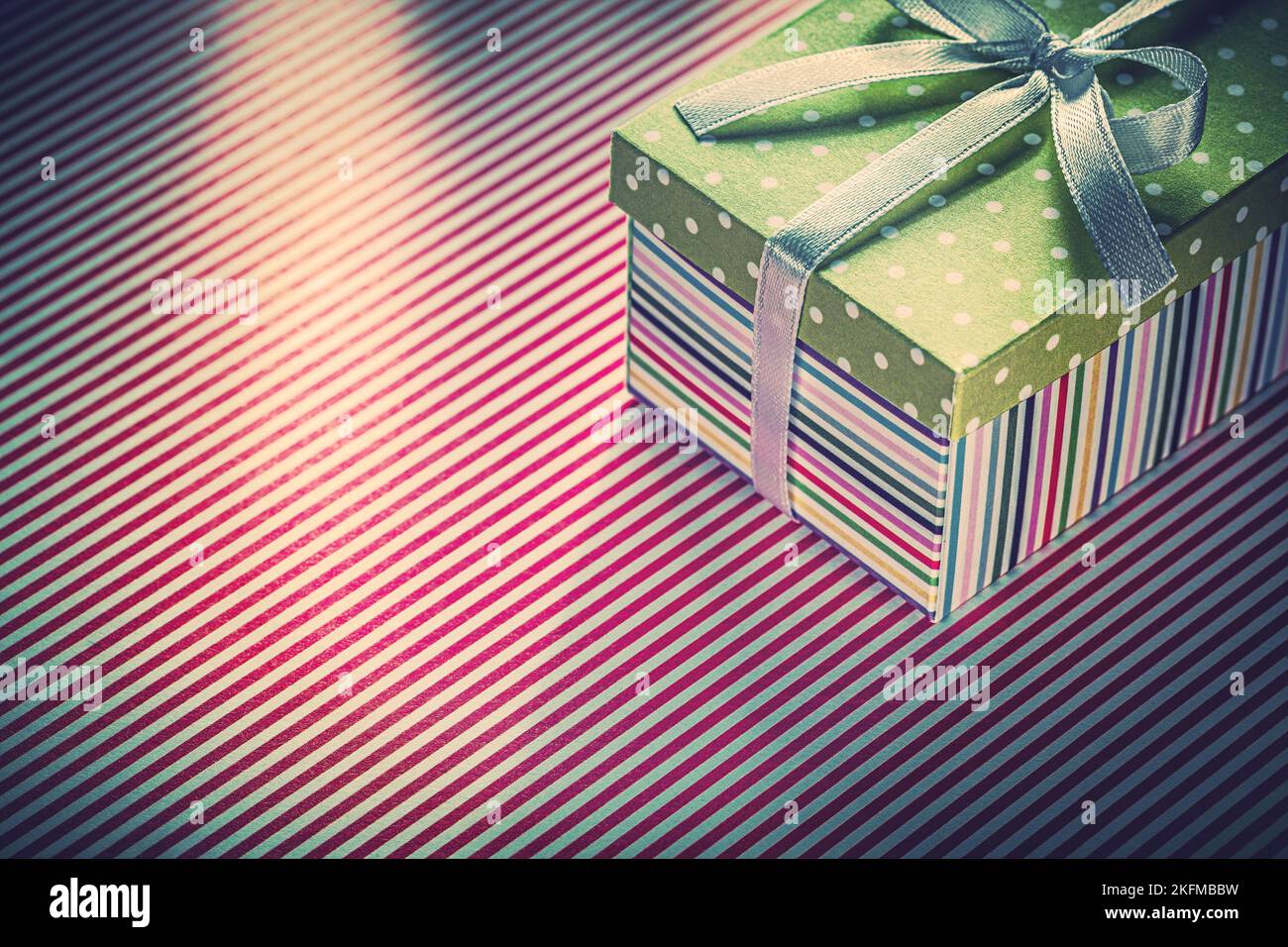 Present in cardboard box on red striped tablecloth celebrations concept ...