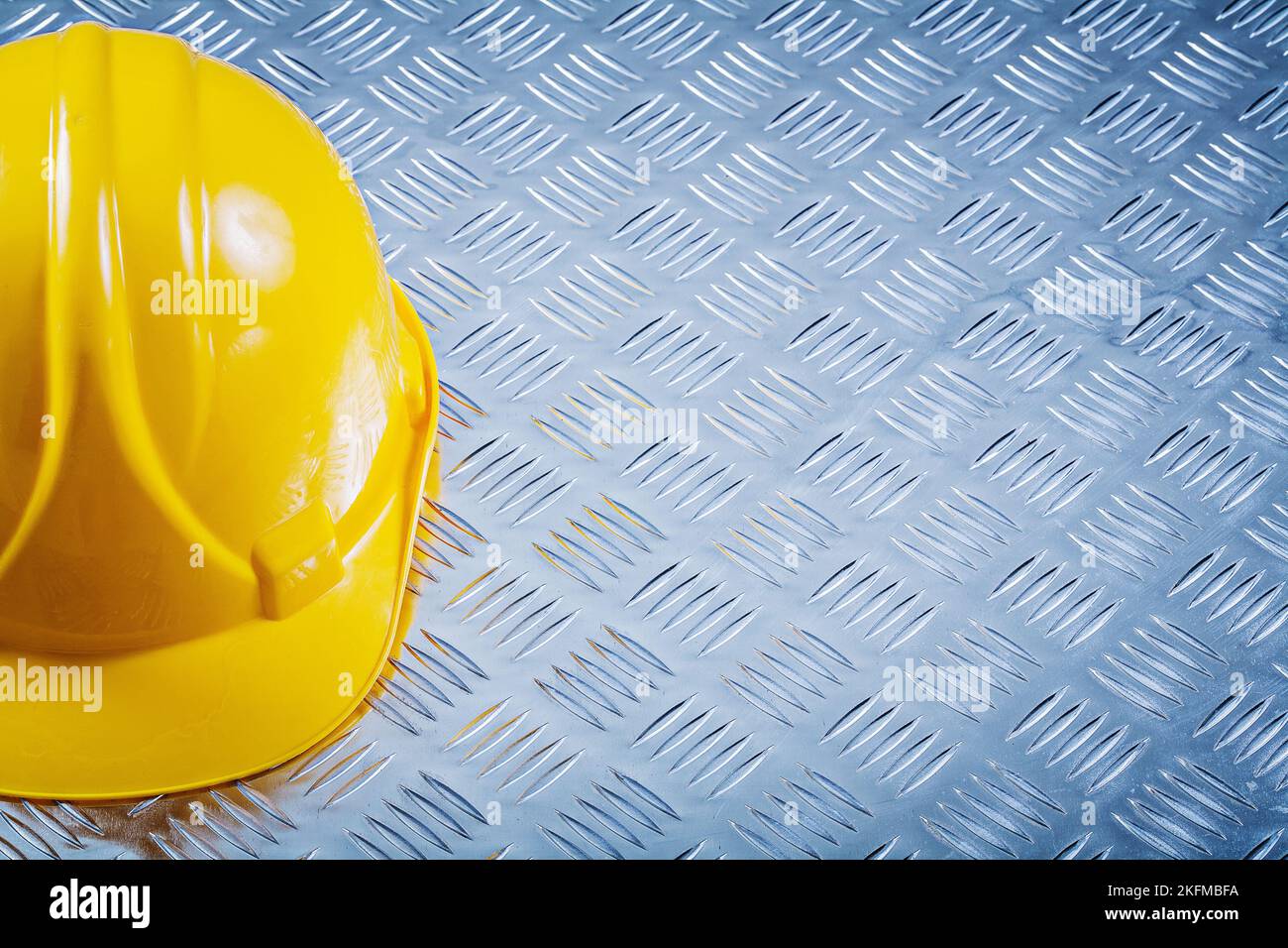 Protective building helmet on chequered metal sheet copy space ...