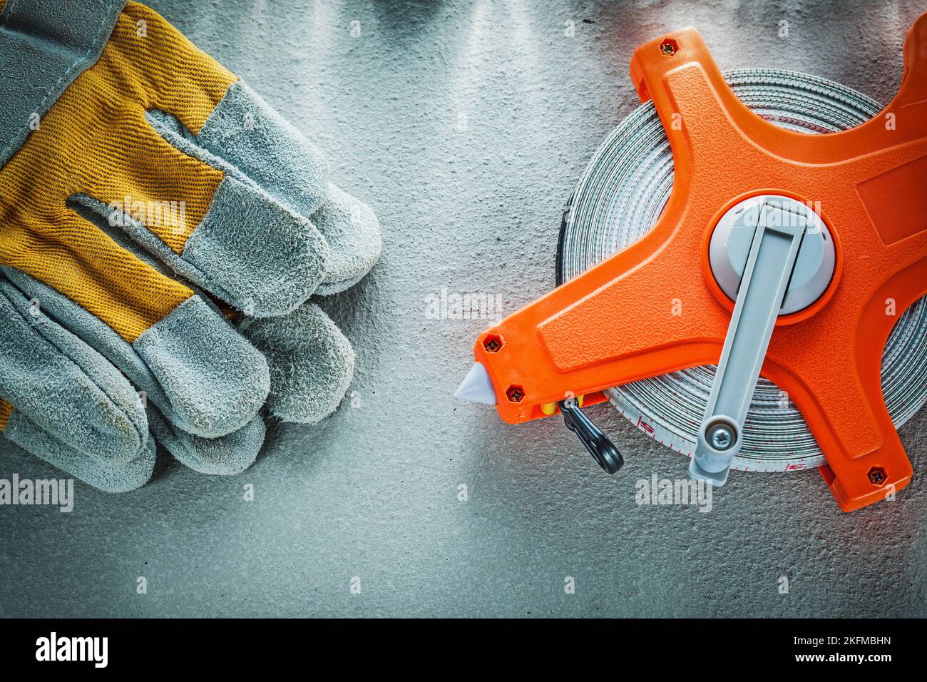 Protective gloves measuring tape on concrete background Stock Photo - Alamy