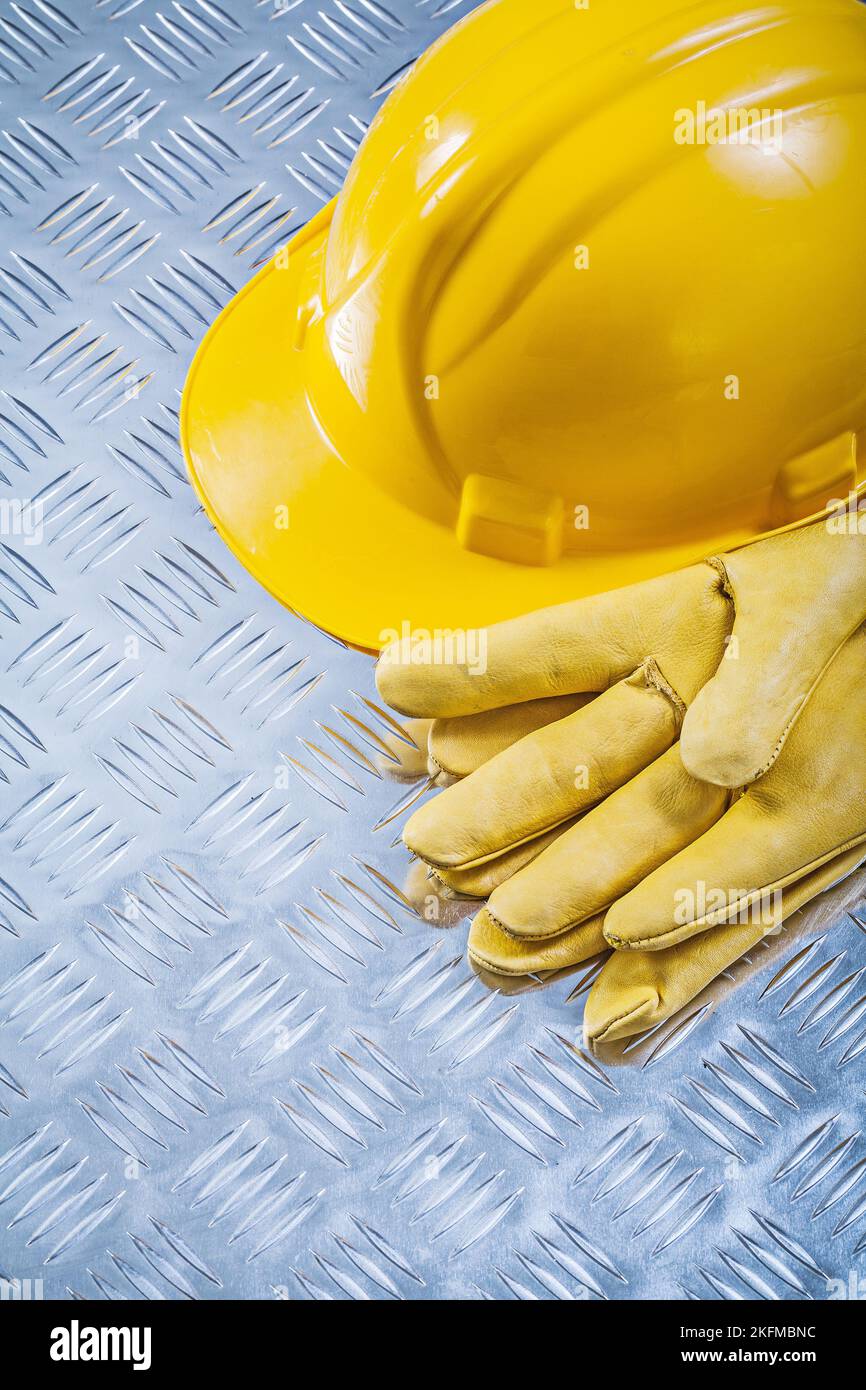 Protective leather gloves hard hat on channeled metal sheet ...