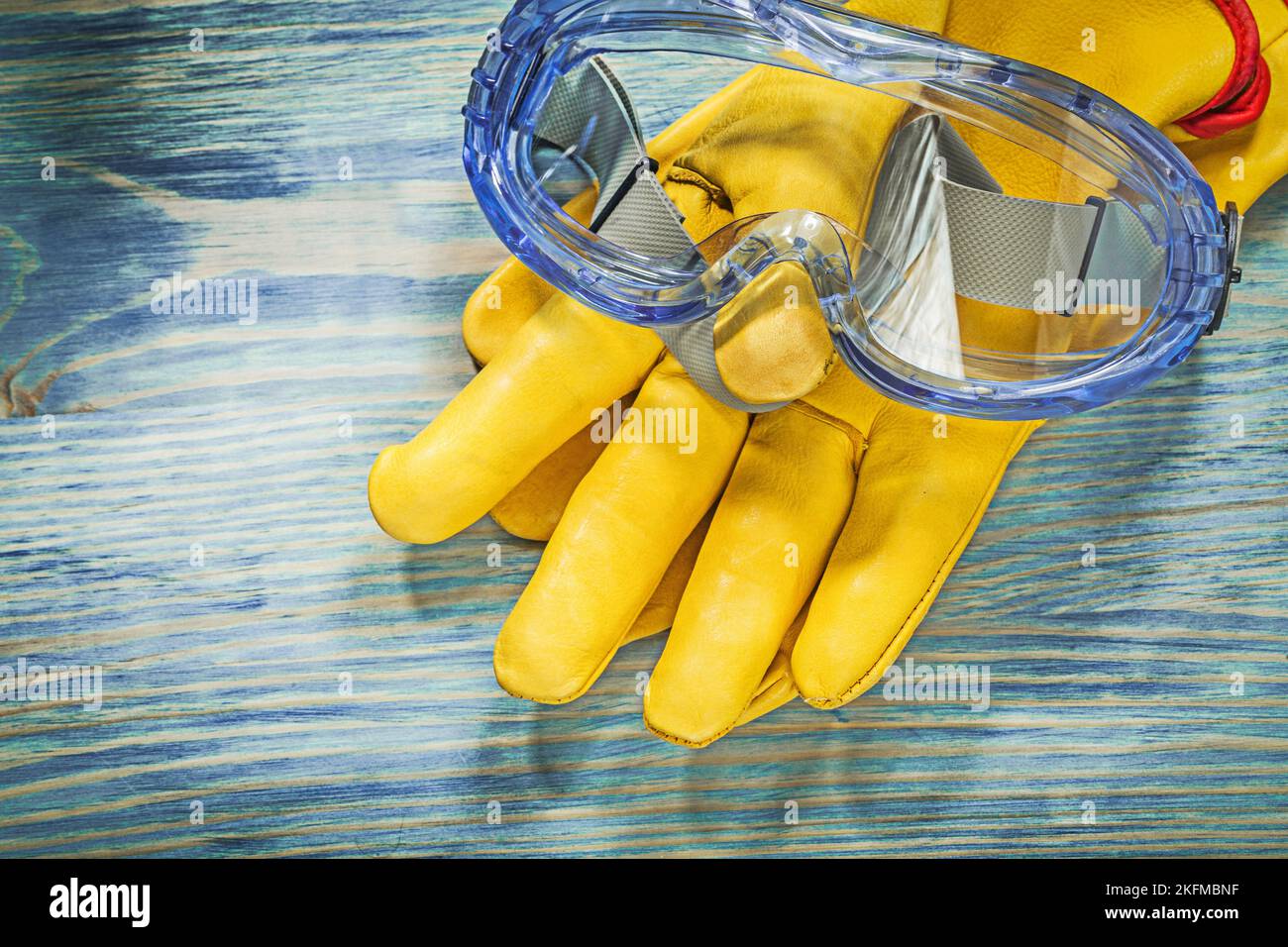 Protective leather gloves goggles on wooden board construction concept ...