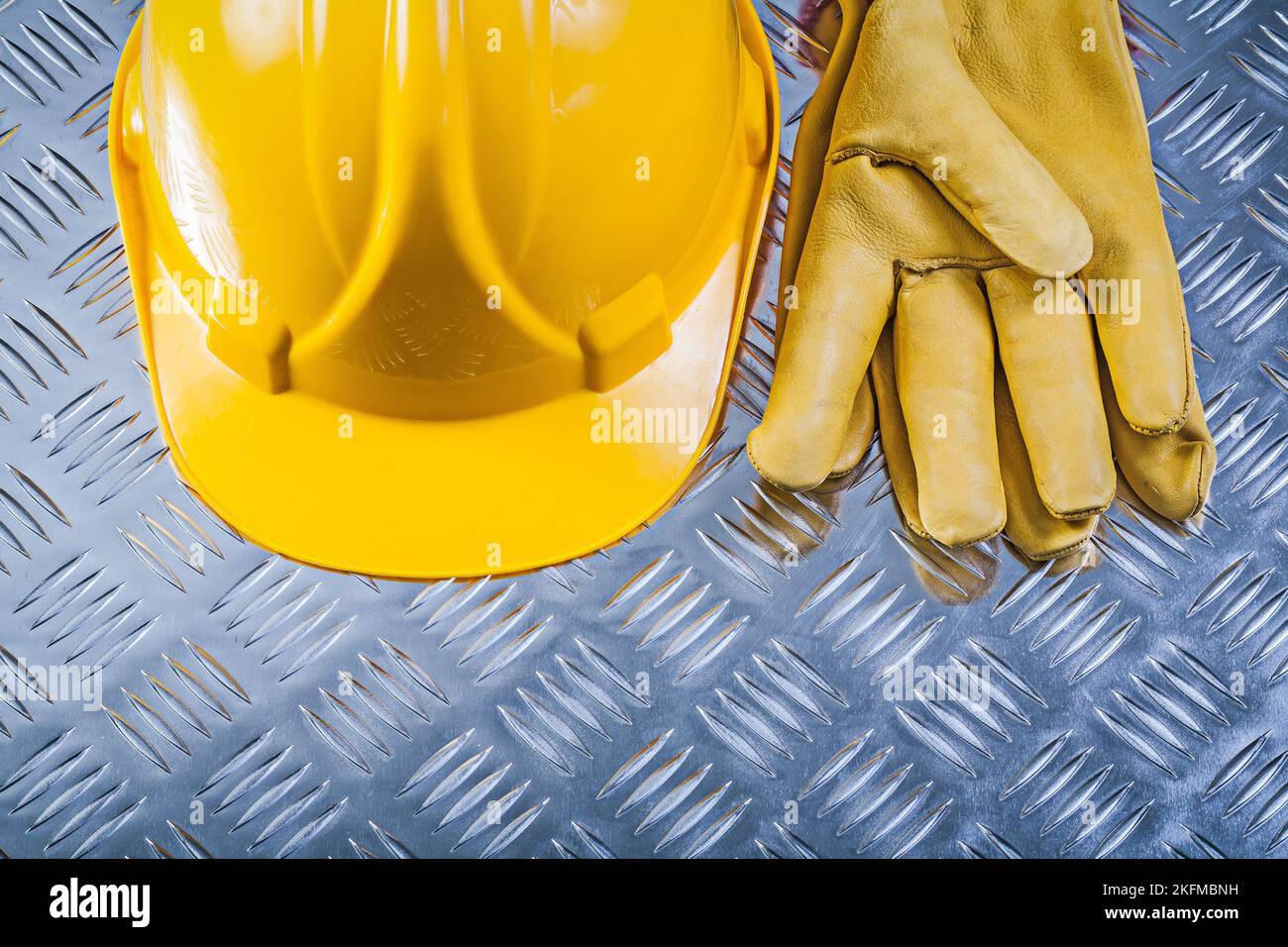 Protective leather gloves hard hat on corrugated metal background ...