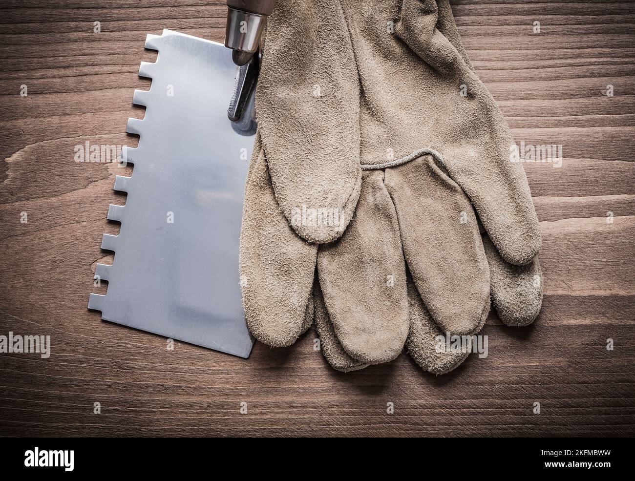 putty spattle and safety glove on wood board Stock Photo - Alamy