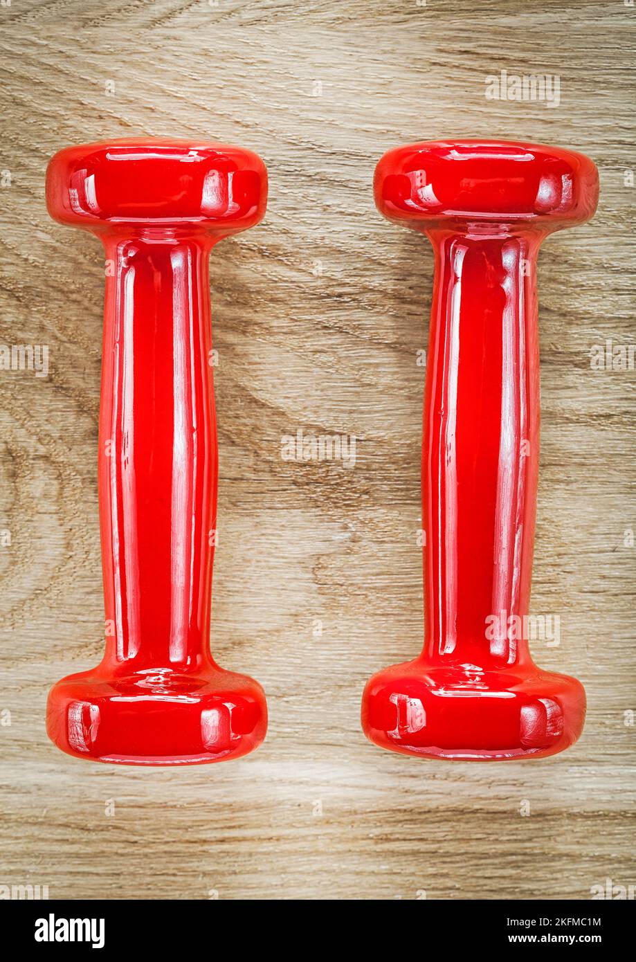Red dumbbell weights on wooden board sports training concept Stock ...