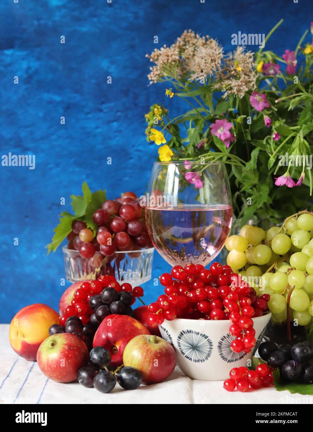 Still life with glass of rose wine, fresh seasonal berries and fruit ...