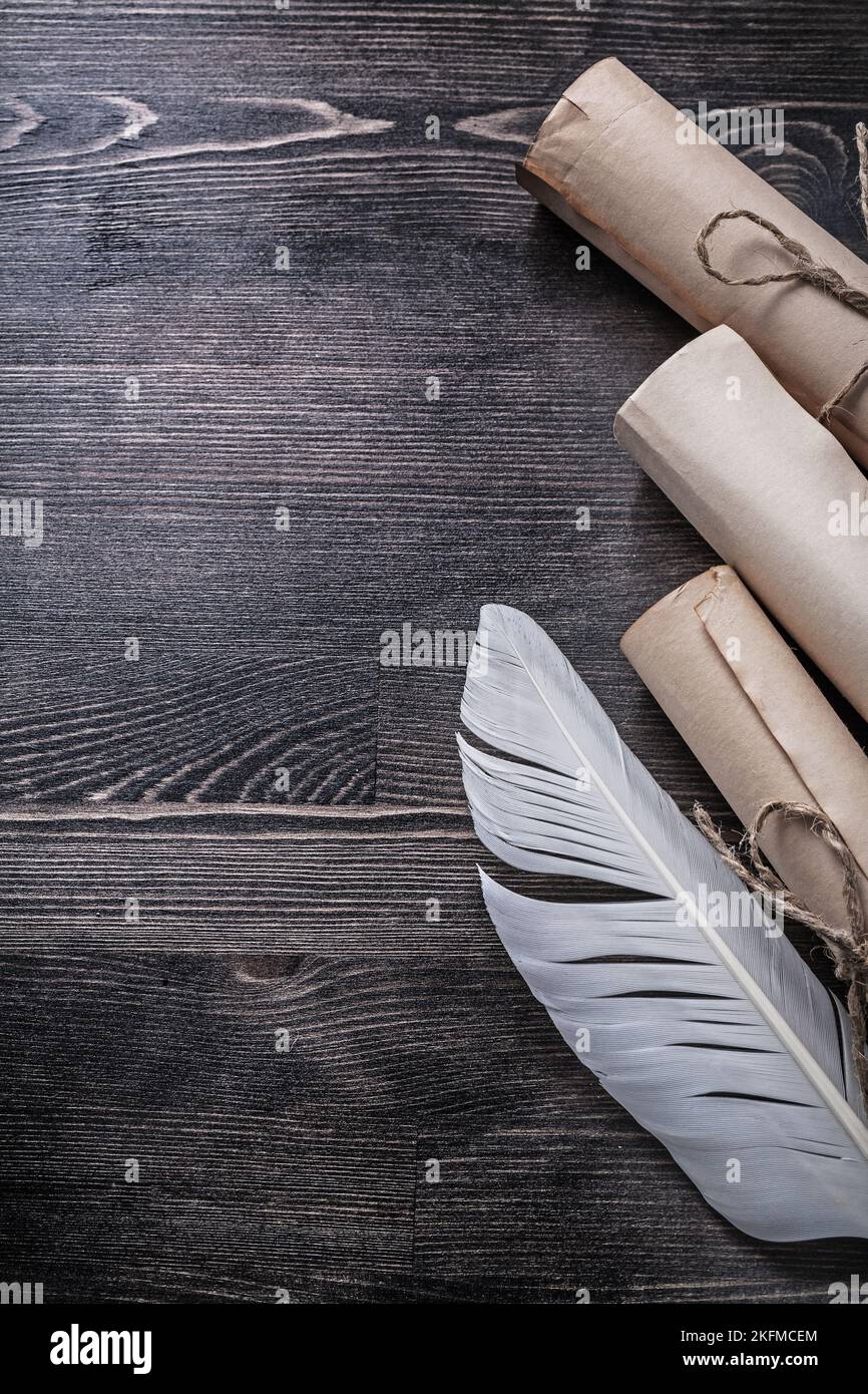 Rolled ancient documents feather on wooden board top view Stock Photo ...
