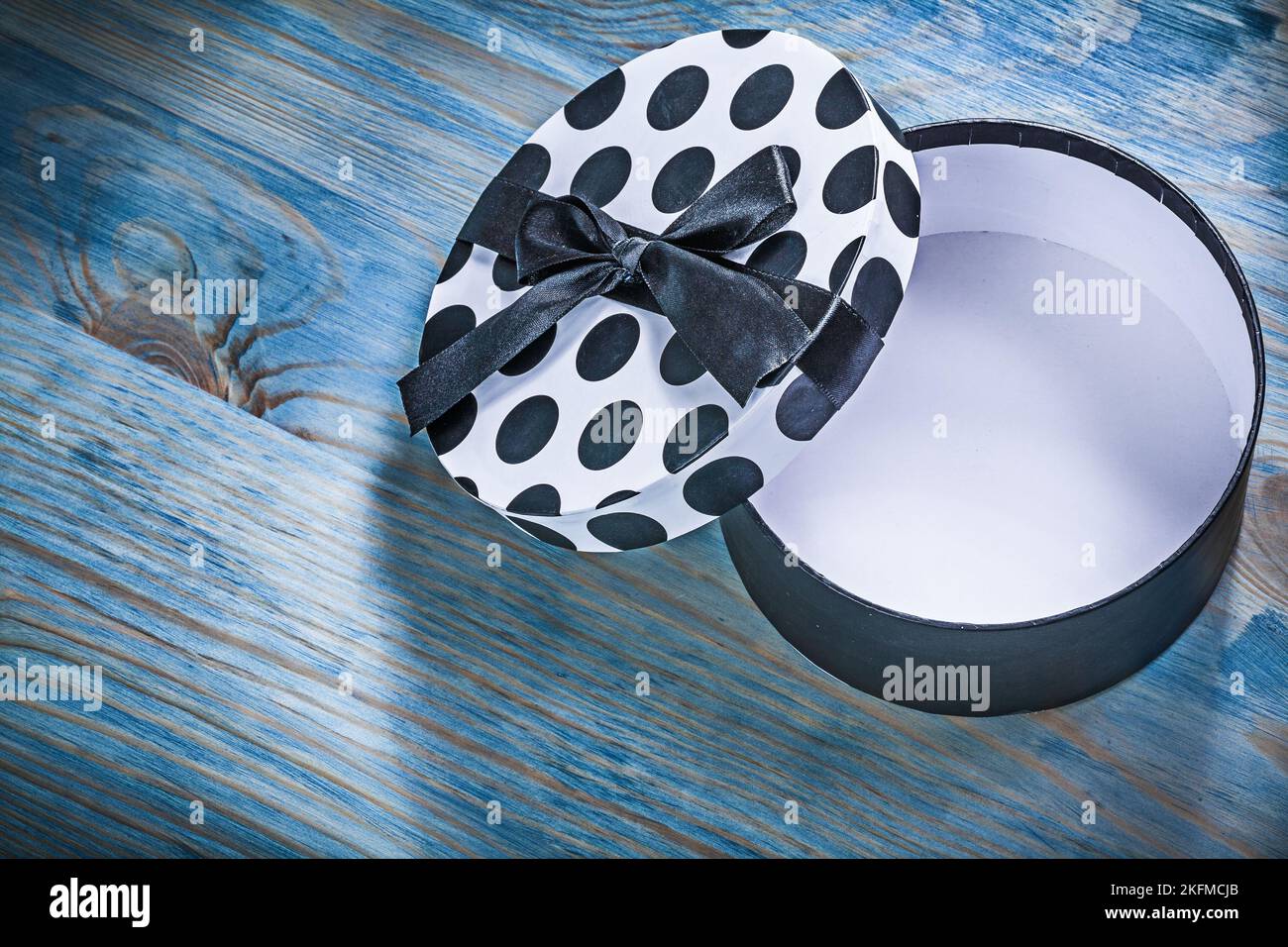 Round opened gift box with blue bow on wooden board holidays concept ...