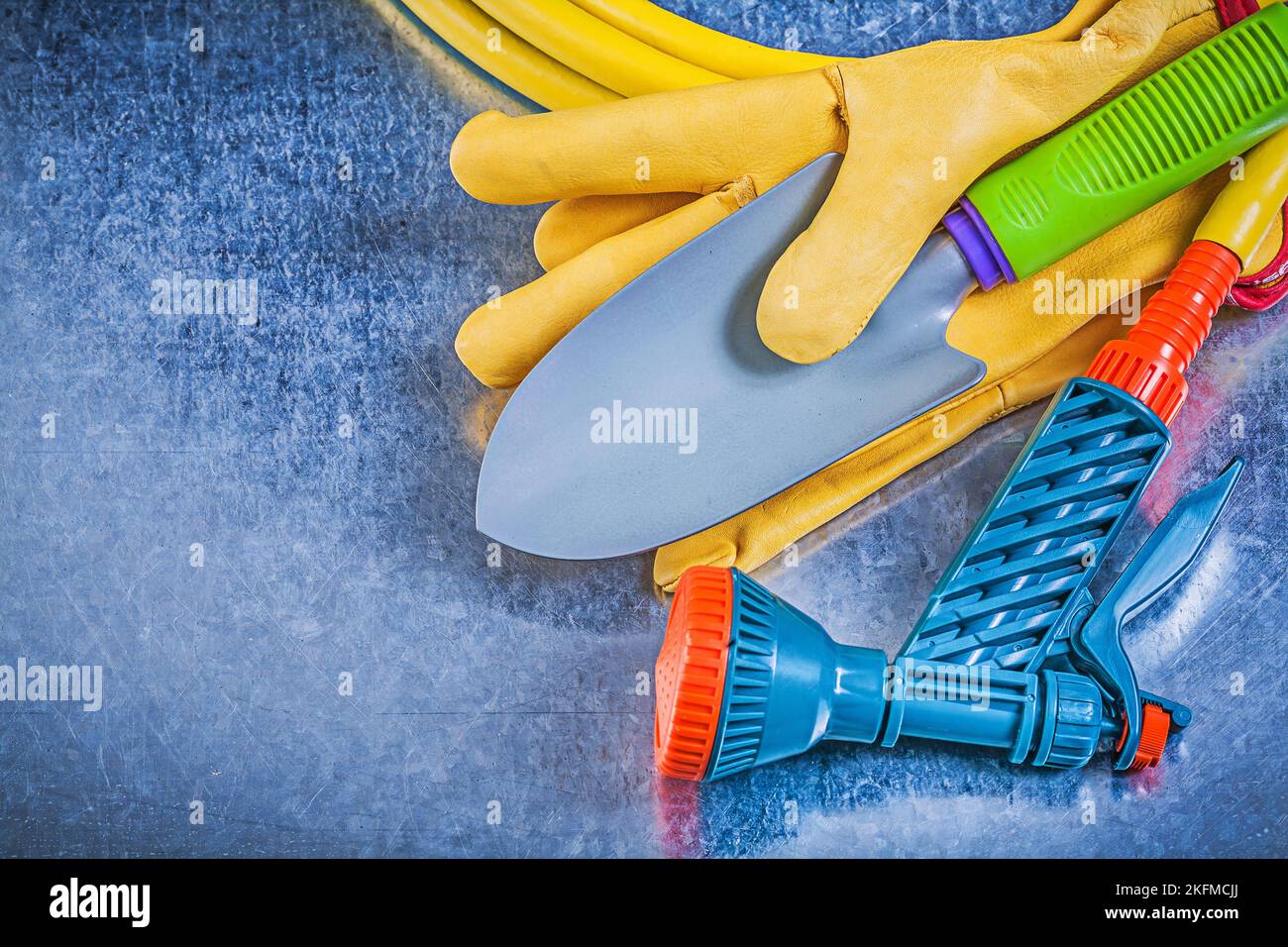 Rubber garden hose water sprayer protective gloves spade on metallic ...