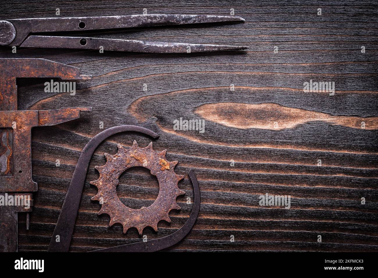 Rusted vintage calipers and cog-wheel on vintage wooden board ...